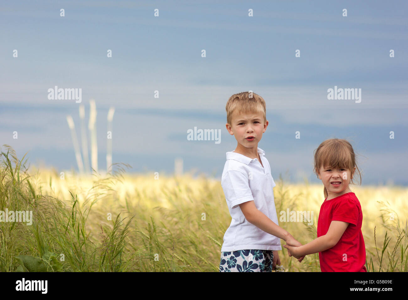 Little boy and little girl holding hands looking very displeased and ...