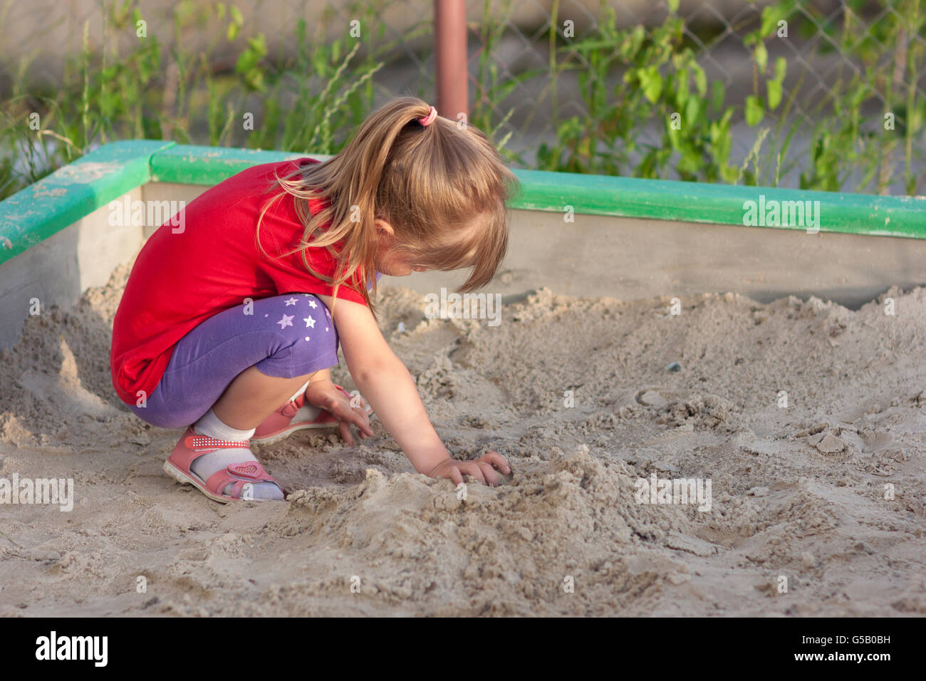 Little girl playing in sandbox on a sunny summer day Stock Photo - Alamy