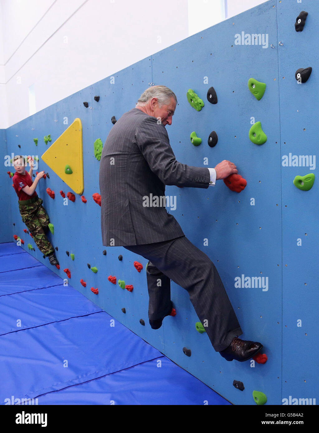 The Prince of Wales climbs on the traversing wall in the new gym at ...