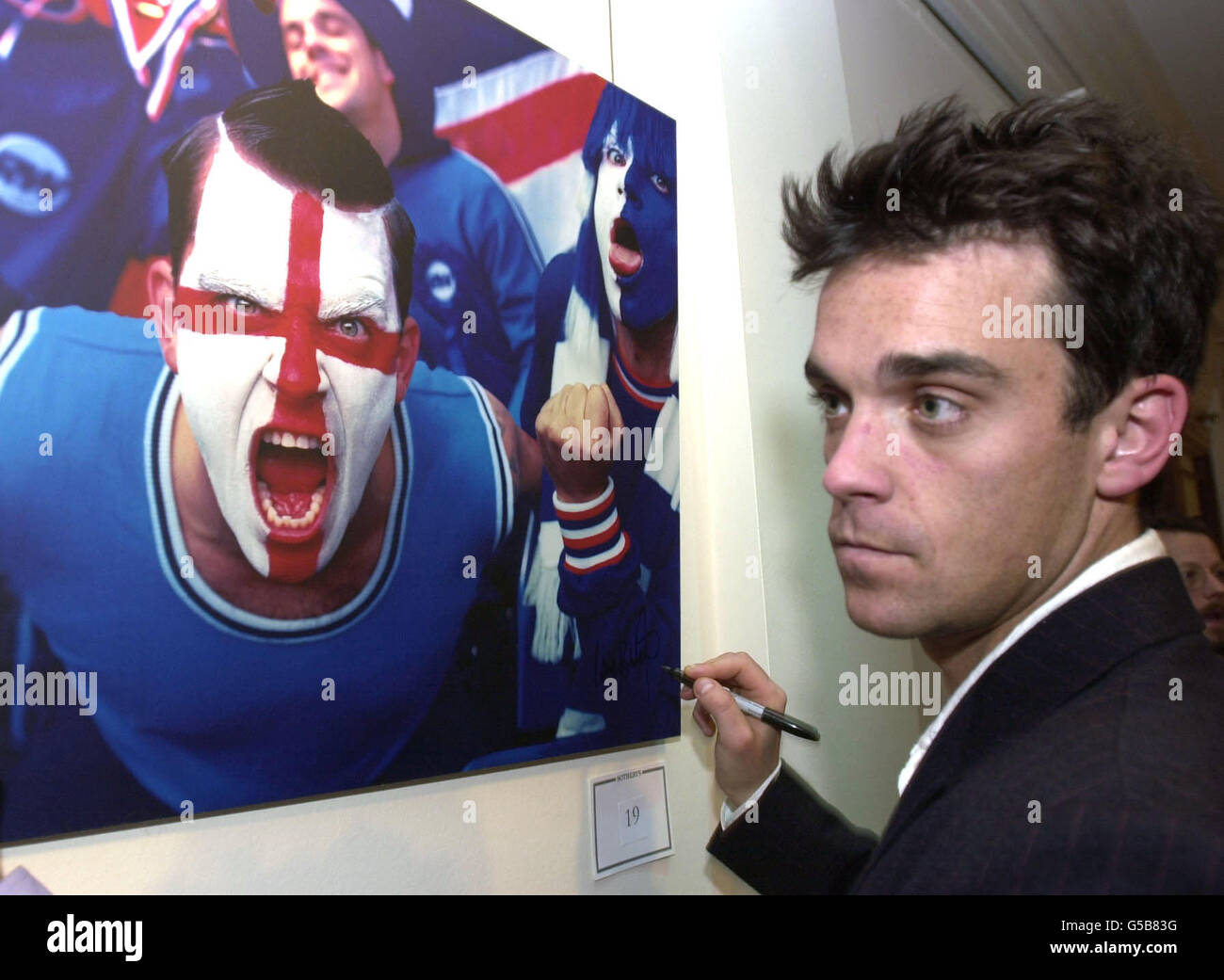 Singer robbie williams autographs artwork from his last album hi-res ...