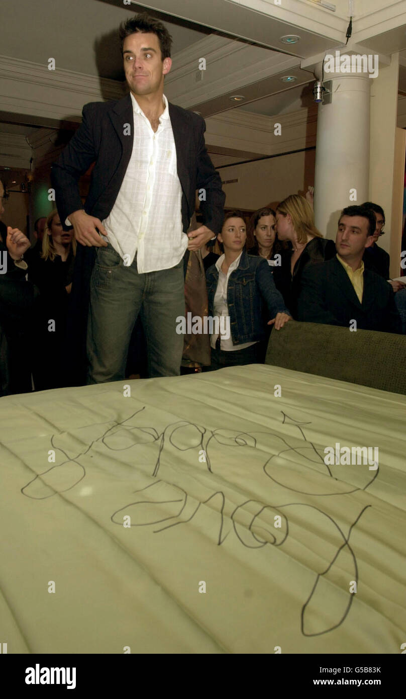 : Singer Robbie Williams on his bed at Sotheby's in London. The bed is ...