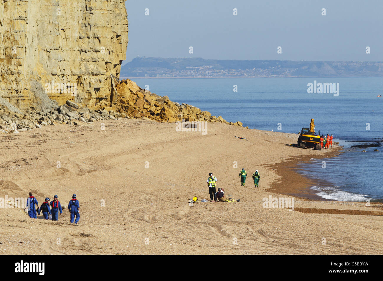 Rescuers work at the scene of a cliff landslide near Burton Bradstock ...