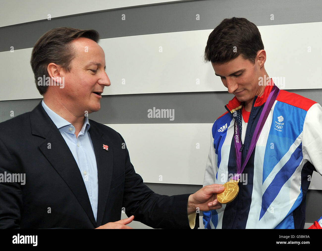 Prime Minister David Cameron holds the gold medal won by Peter Wilson ...