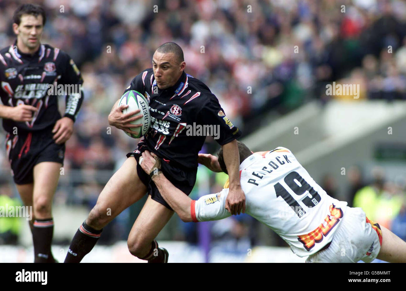 St Helens' Tony Sullivan (left) pulls away from the tackle of Bradford ...