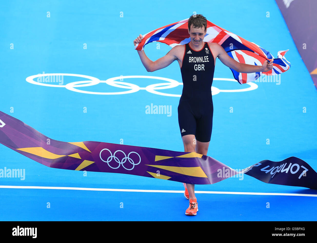 Great Britain's Alistair Brownlee celebrates as he crosses the finish ...