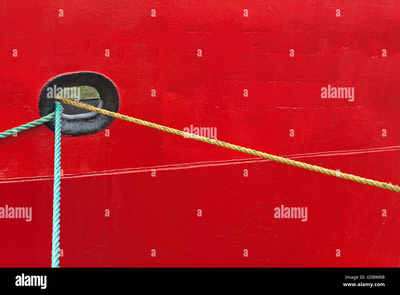 ropes through porthole in red ship Stock Photo - Alamy