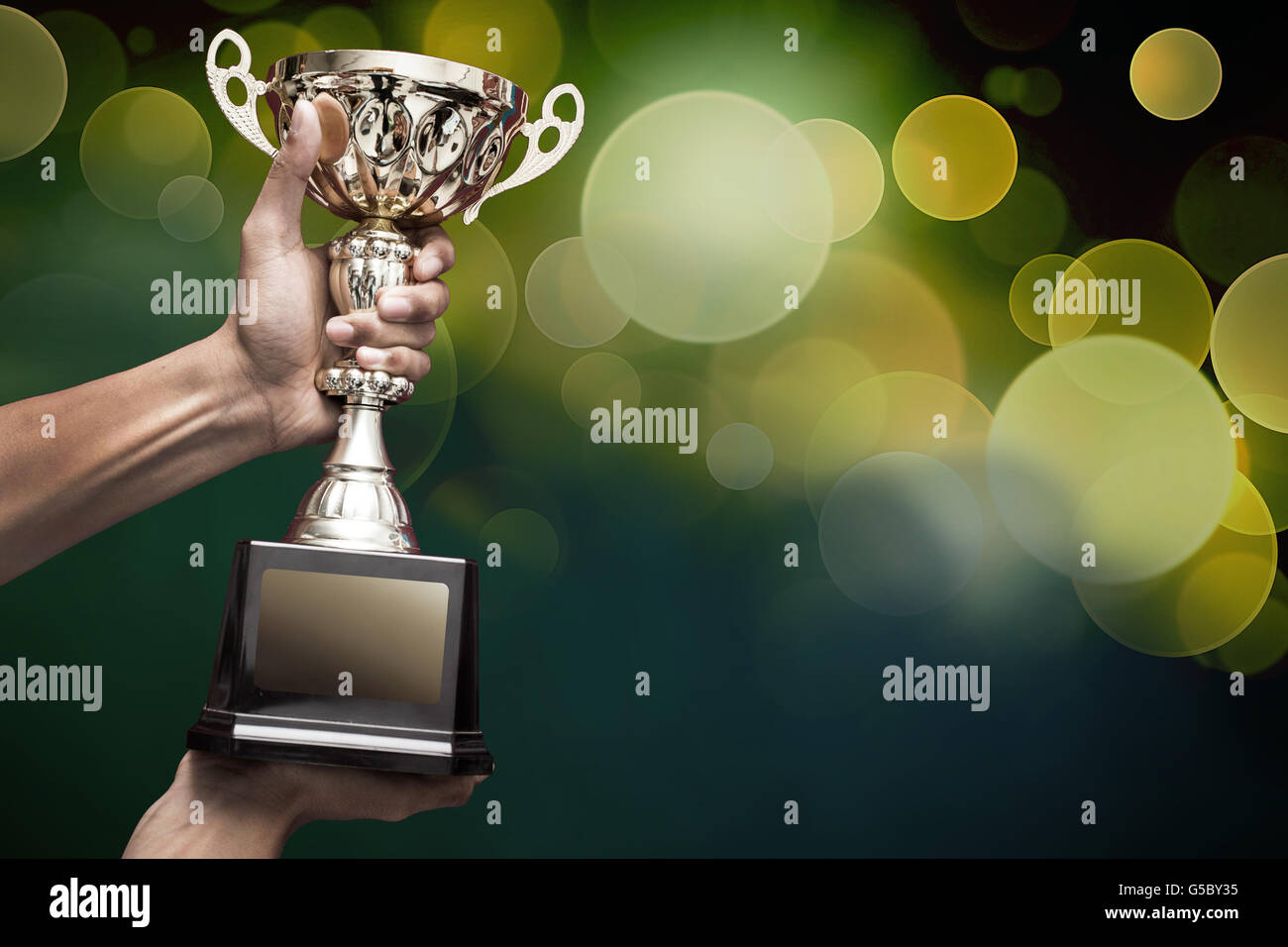 hand holding up a gold trophy cup as a winner in a competition Stock ...