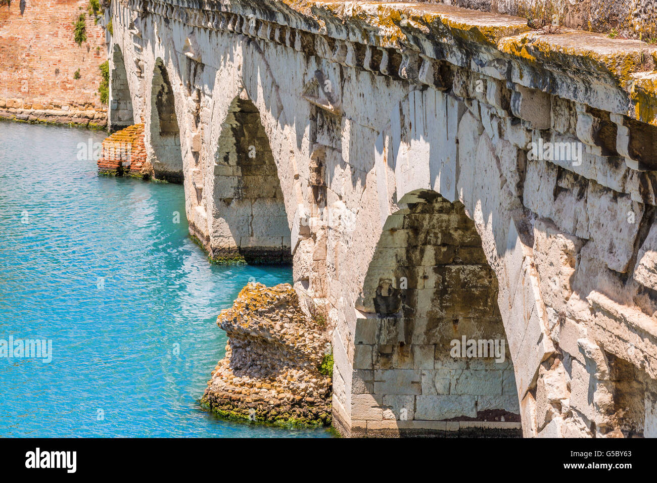clear water under the arches of the Roman bridge of Augustus Stock ...