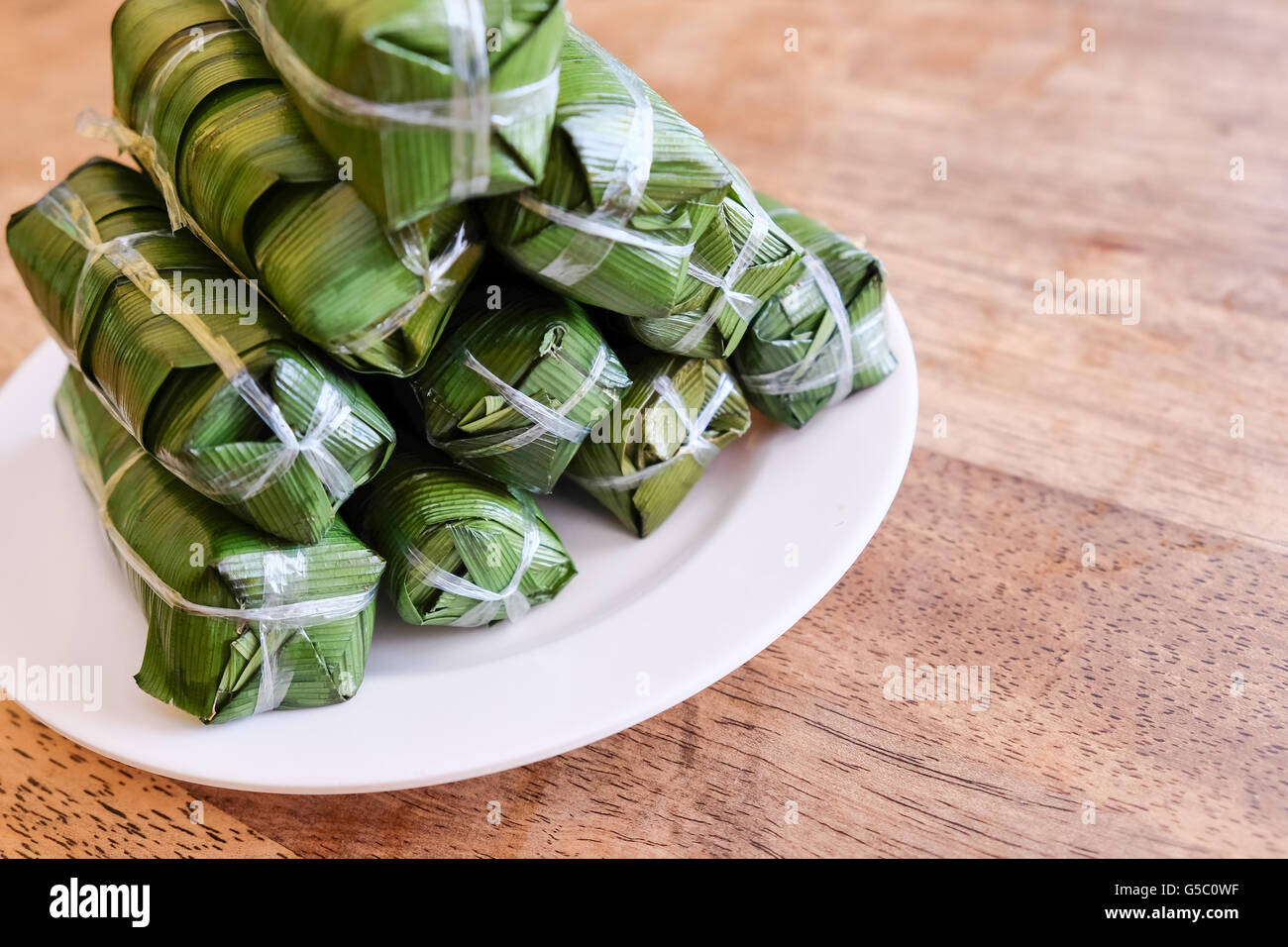 sticky rice cakes. A glutinous rice wrapped in leaves Stock Photo - Alamy