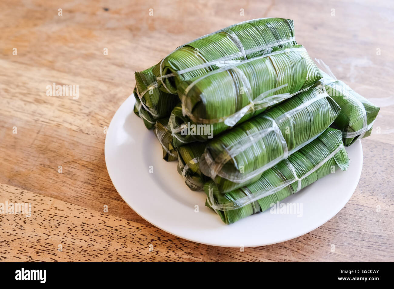 sticky rice cakes. A glutinous rice wrapped in leaves Stock Photo - Alamy