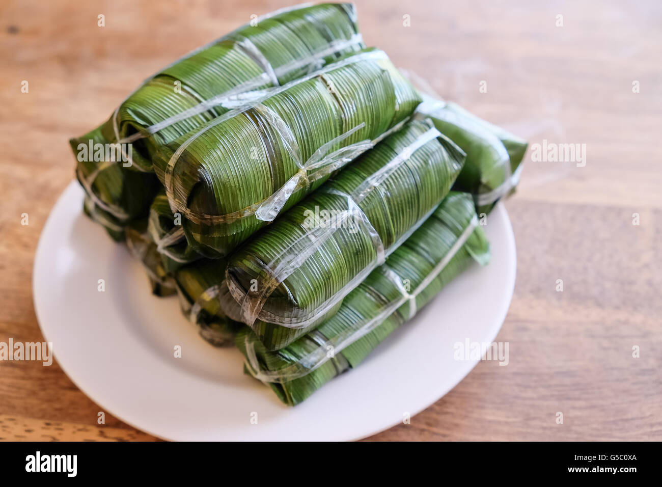 sticky rice cakes. A glutinous rice wrapped in leaves Stock Photo - Alamy