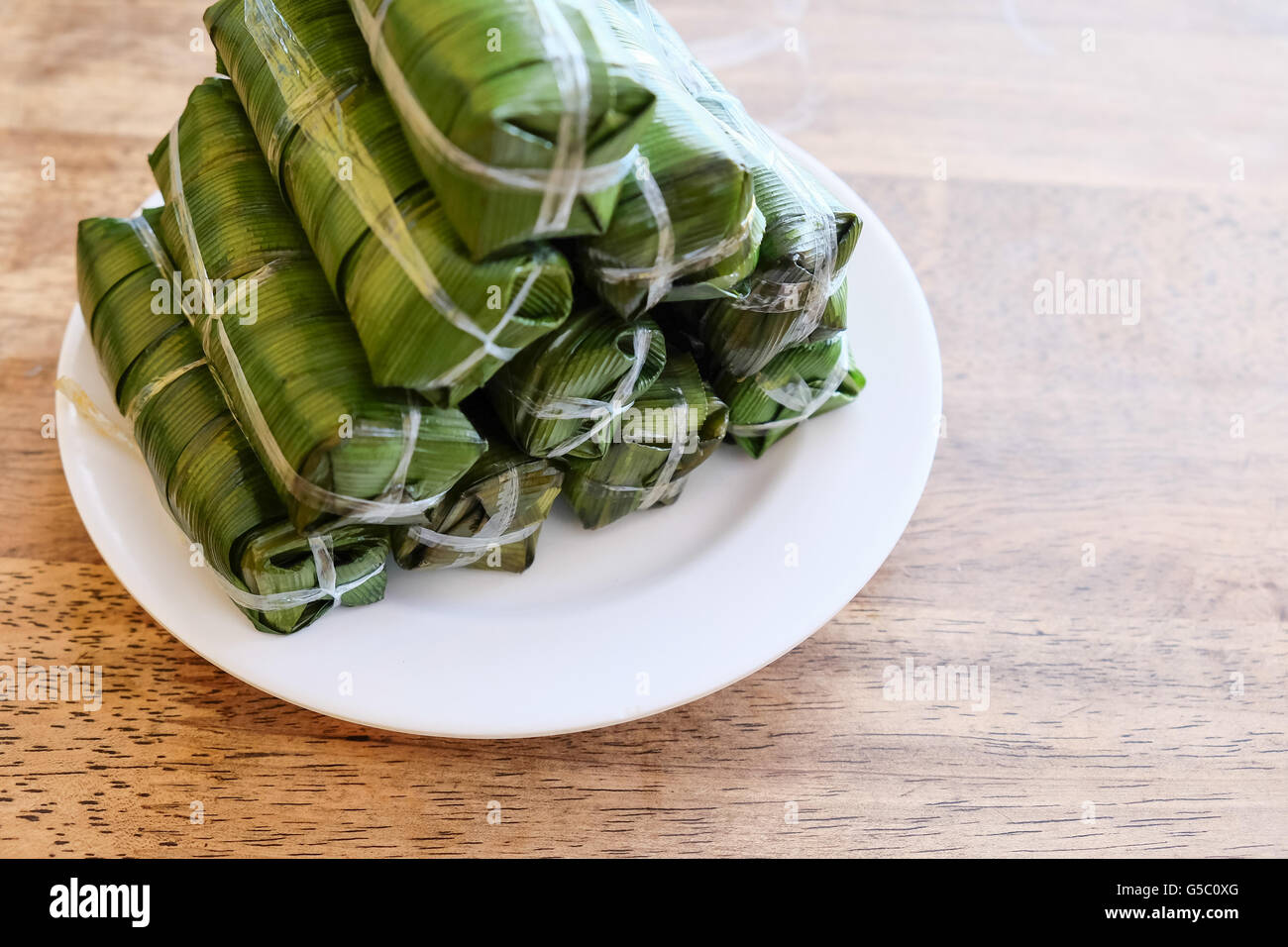 sticky rice cakes. A glutinous rice wrapped in leaves Stock Photo - Alamy