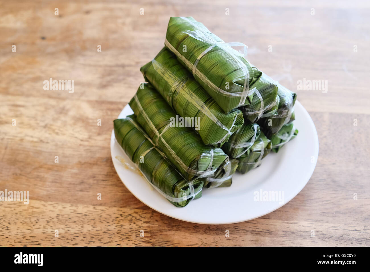 sticky rice cakes. A glutinous rice wrapped in leaves Stock Photo - Alamy