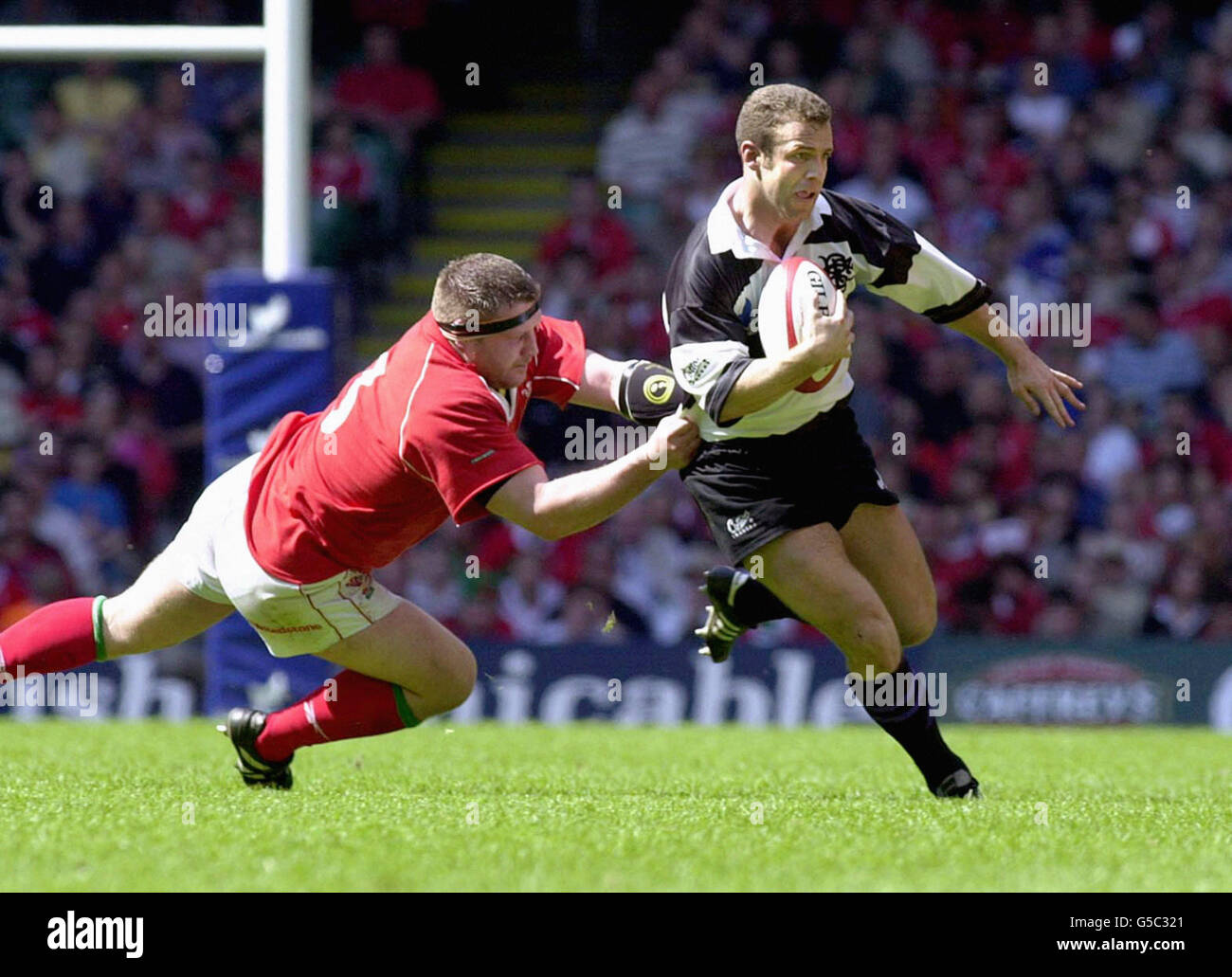 Barbarian's Kevin Maggs (right) is cauight by Wales' captain Dai Young ...