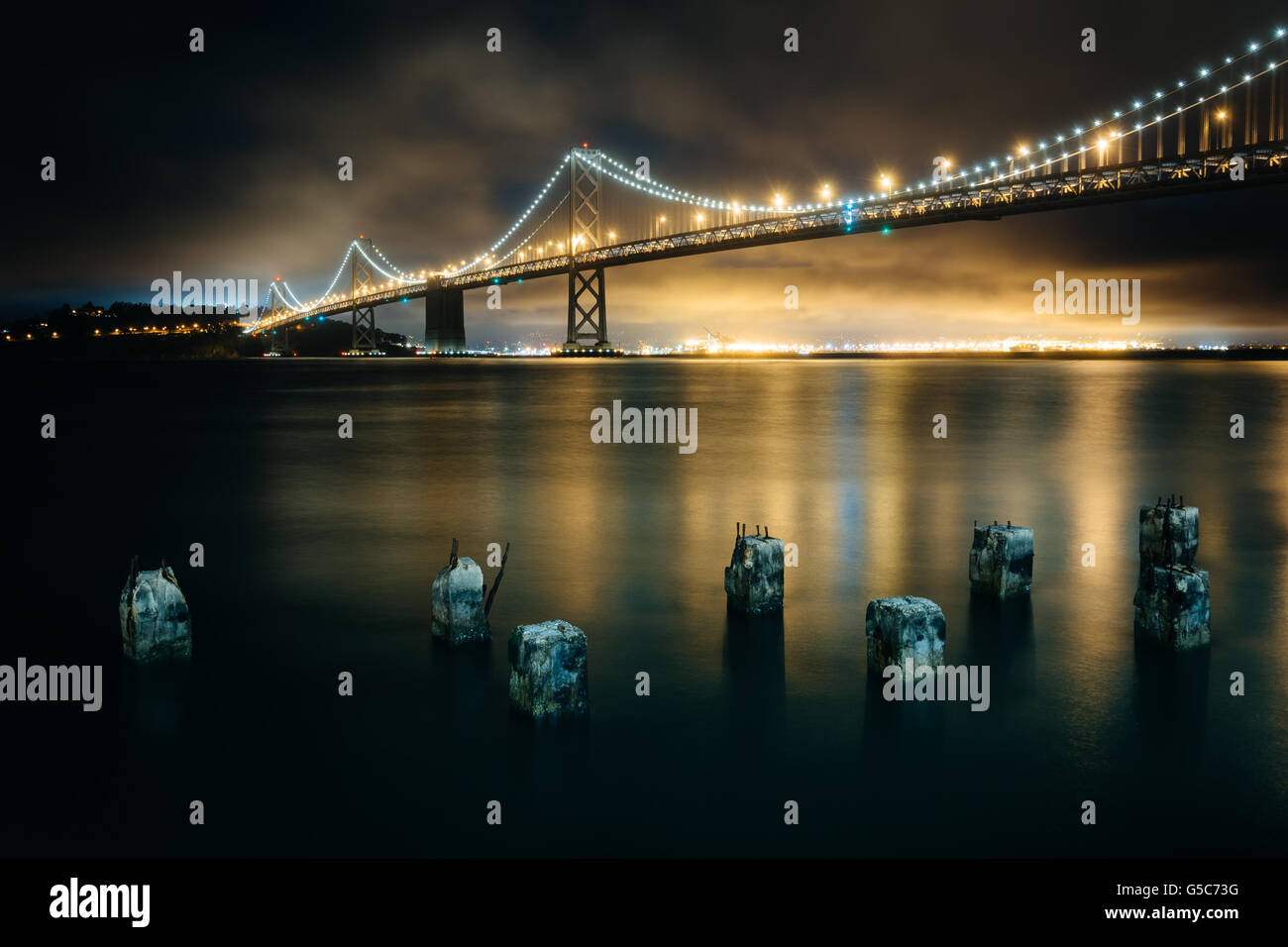 Pier pilings and the San Francisco - Oakland Bay Bridge at night, in ...