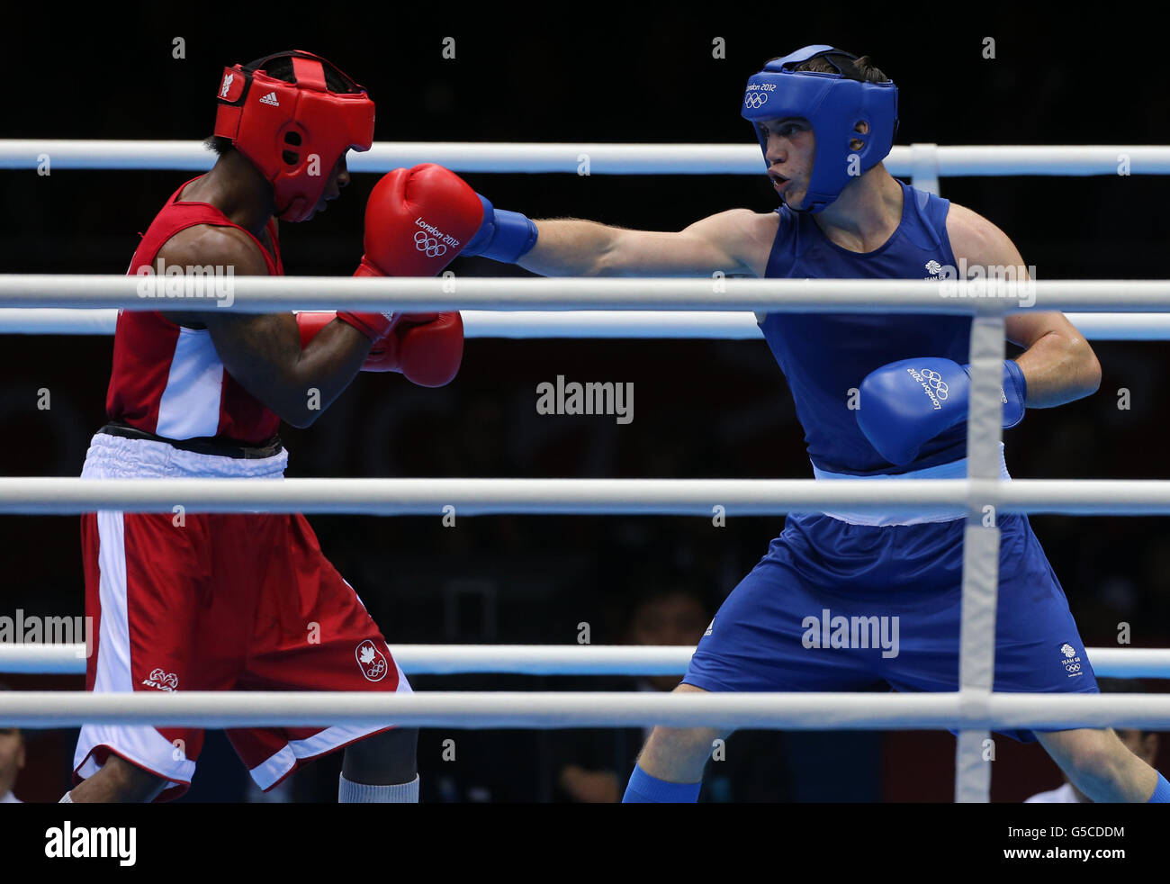 Great Britain's Freddie Evans (blue) receives a punch from Canada's ...