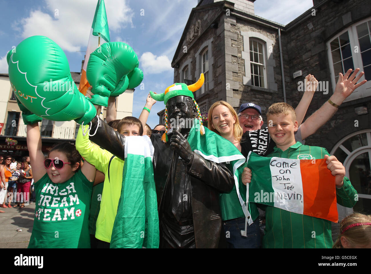 Residents celebrate beside a statue of singer Joe Dolan after watching ...