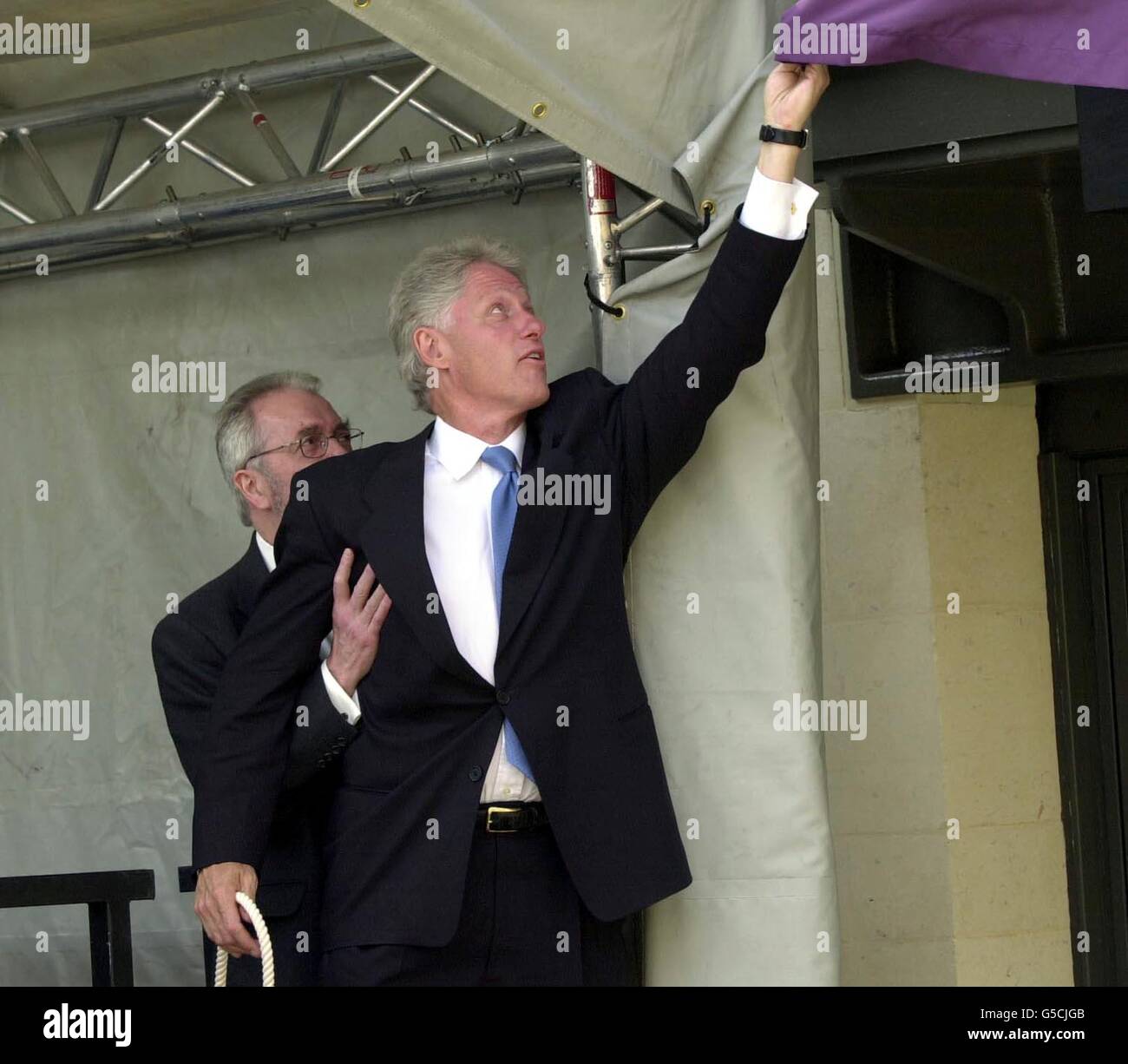 Former US Bill Clinton unveiling a plaque at Oxford, with a little help ...