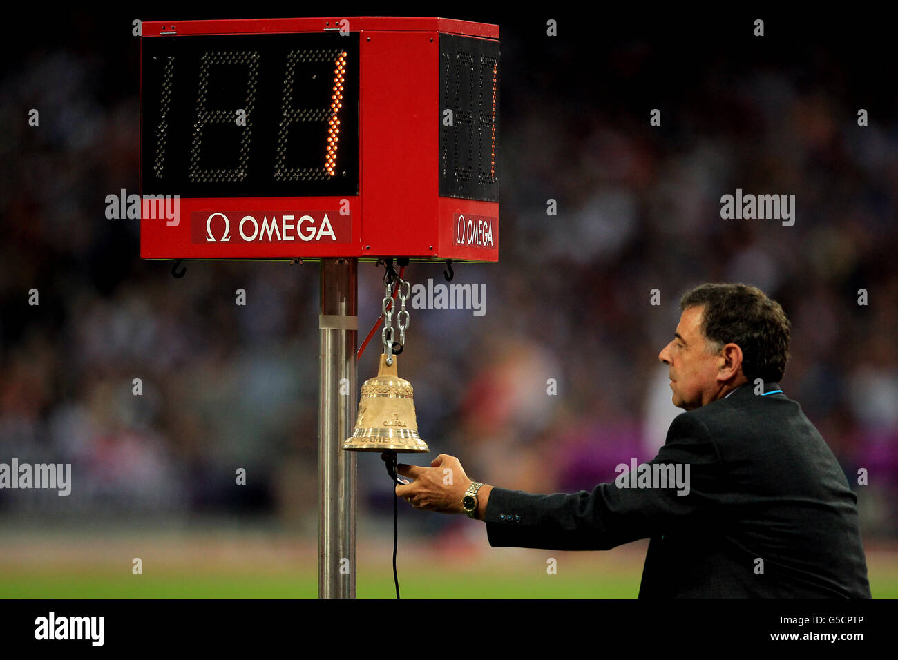 The bell is rung by an official to alert athletes of the final lap at ...