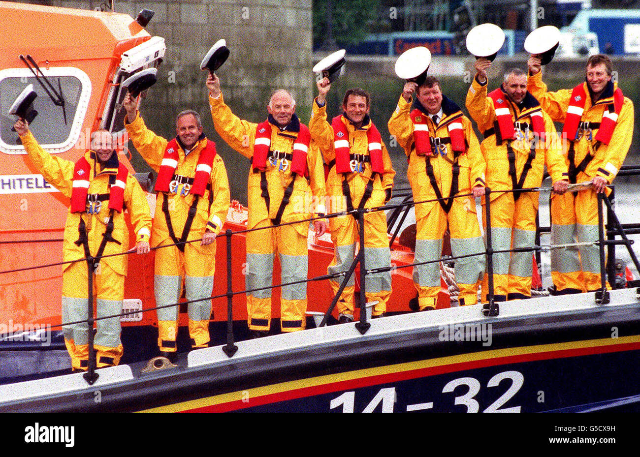 Uniform yellow waterproof clothes hats waving arm raised rescue rnli hi ...