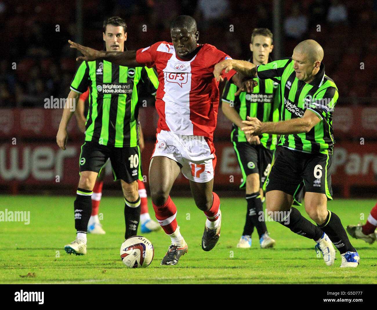 Crawley's John Akinde (centre) takes on Brighton's Adam El-Abd during ...
