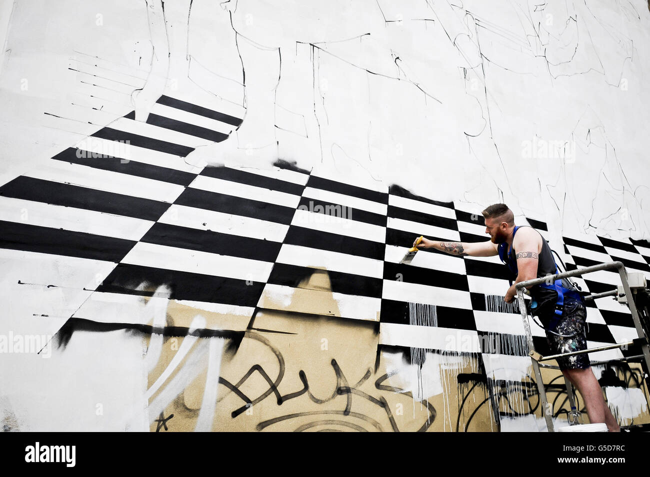 STANDALONE PHOTO An artist rides on a cherry picker as he begins a huge ...