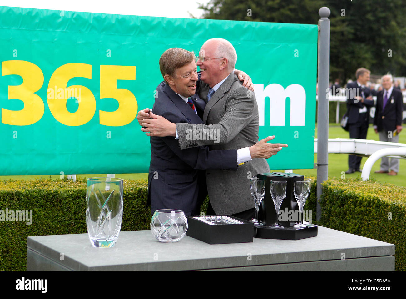 TV presenter Henry Kelly (left) hugs trainer Mick Channon during the ...
