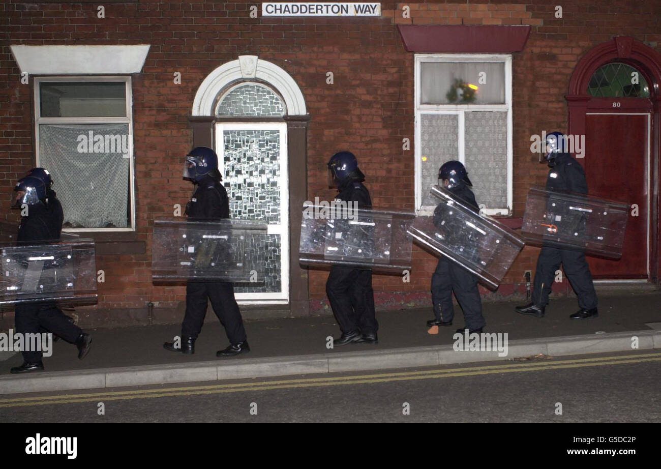 Police in full riot gear walk along a street in Oldham during a second ...