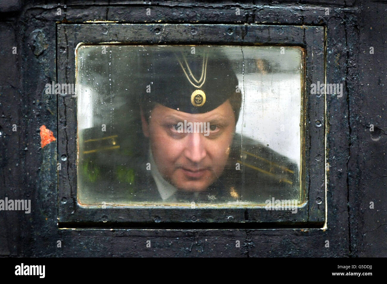 A Russian submariner from RFS Vologda peers out of one of the submarine ...