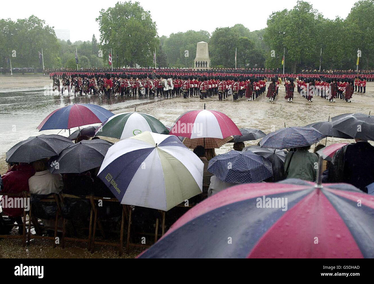Crowds watch the annual Trooping of the Colour parade in heavy rain at ...