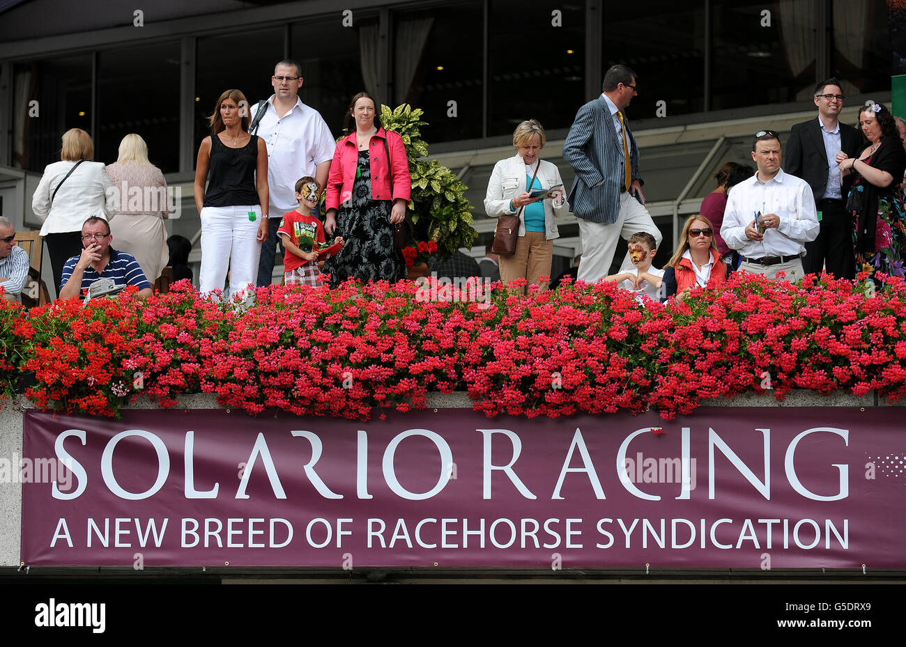 Horse Racing - Family Day - Sandown Park. Racegoers watch horses in the ...