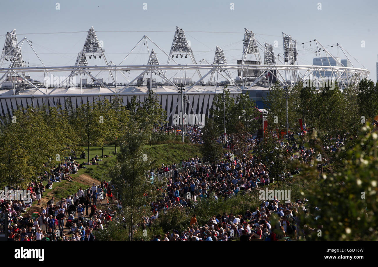 The Olympic stadium is shown as crowds enjoy the sunshine in the ...