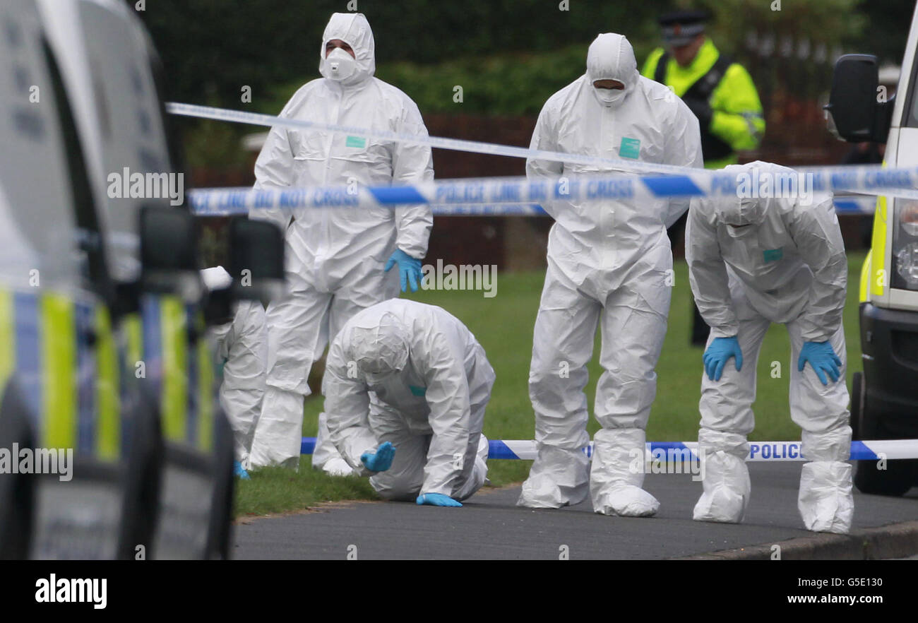 Police forensic officers search the scene of a shooting in Hattersley ...
