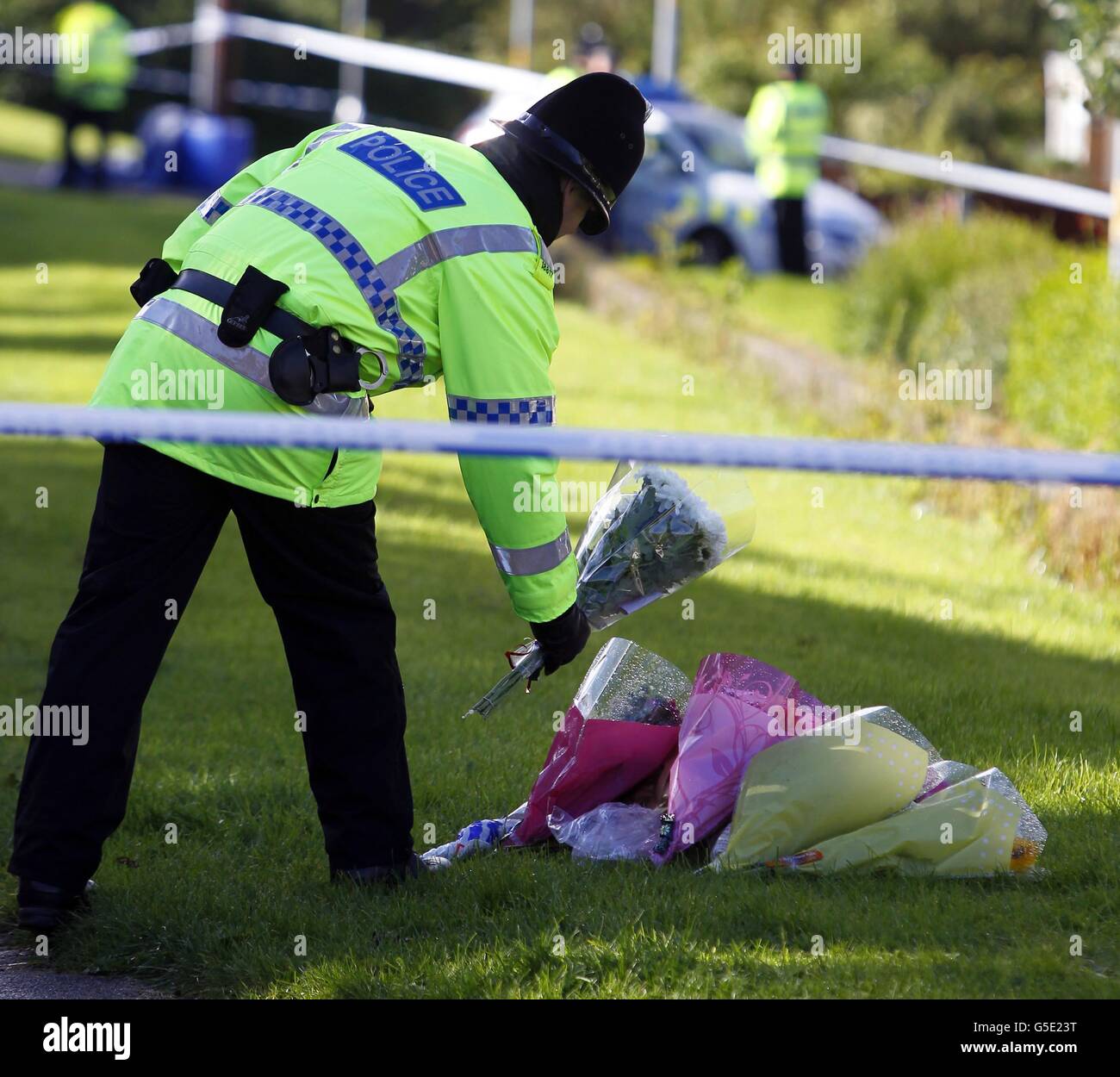 A Greater Manchester Police officer lays flowers at the scene where ...