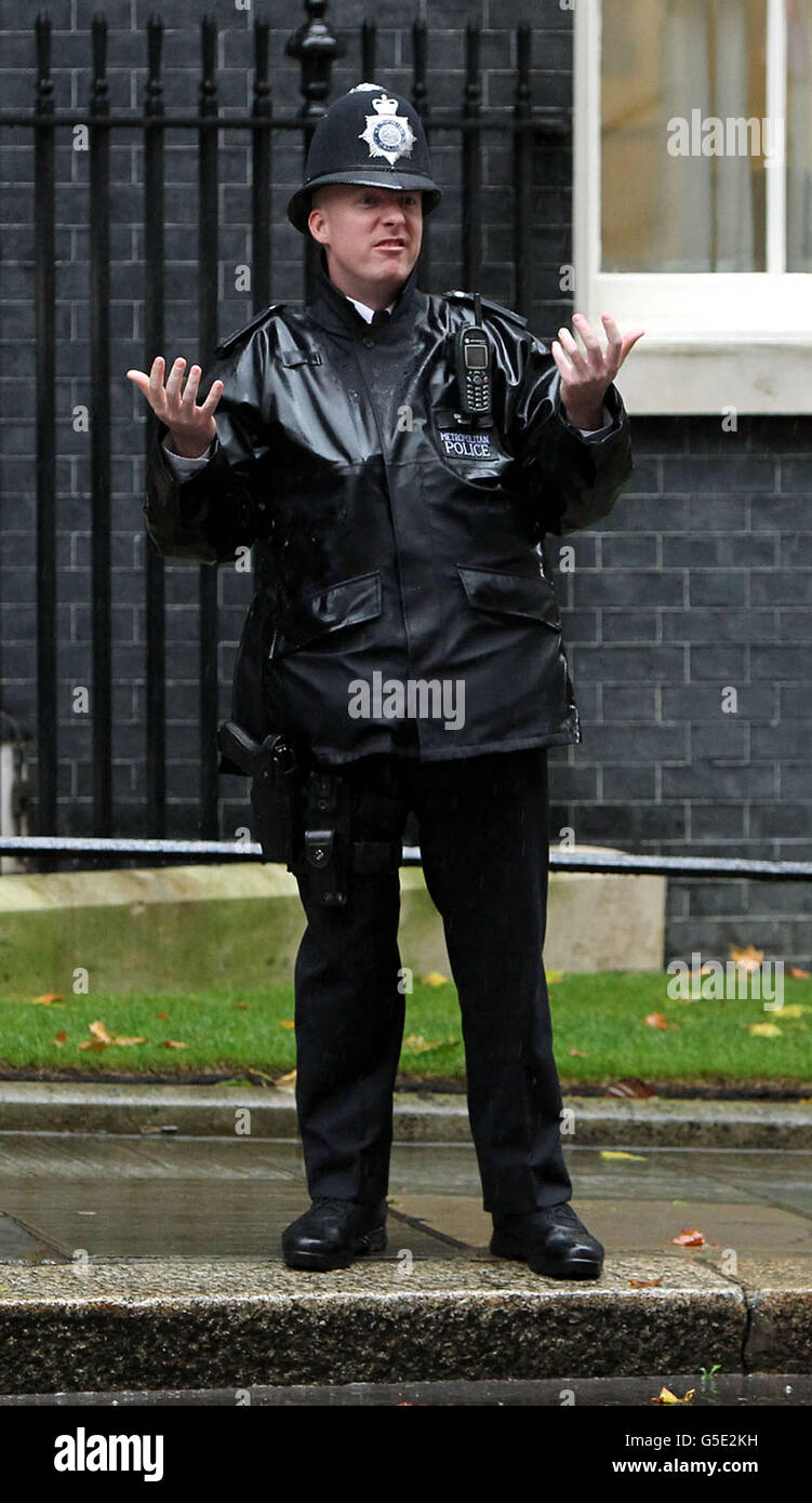 A police officer stands in the rain in Downing Street, London, as ...