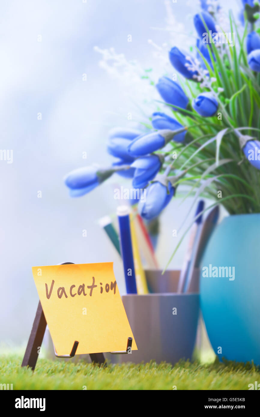 Adhesive note with Vacation text at green office Stock Photo - Alamy