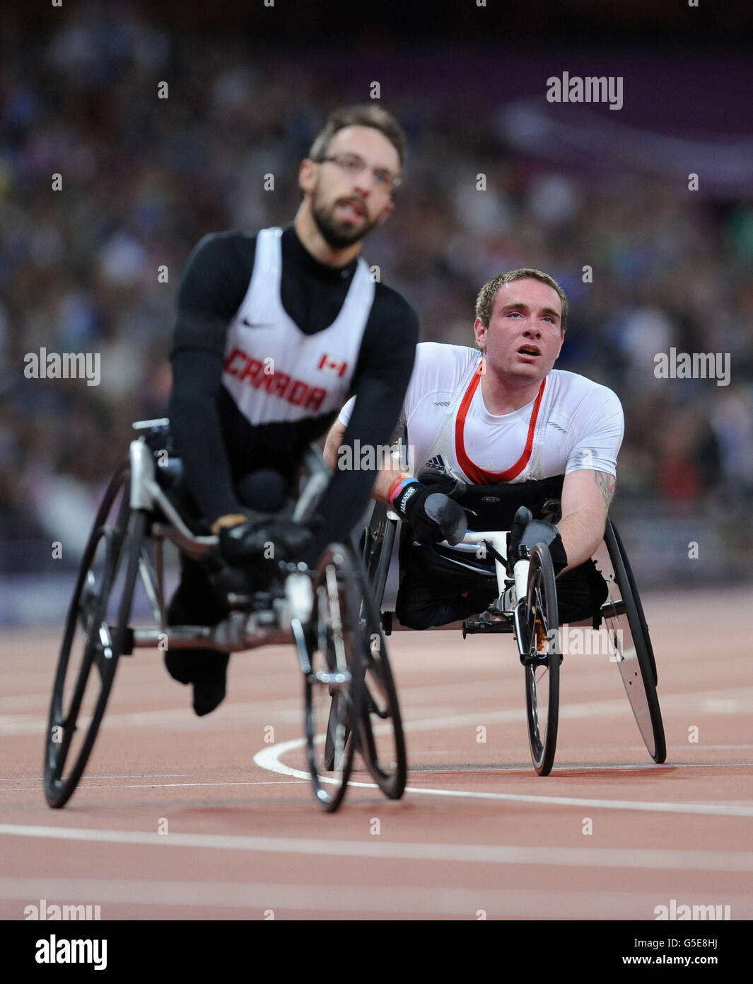 Great Britain's Mickey Bushell (right) reacts after he crosses the line ...