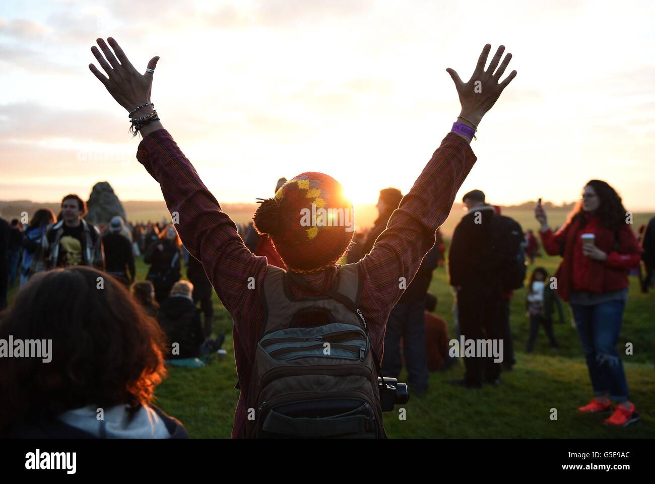 Members of the public watch the sun rise at Stonehenge in Wiltshire as ...