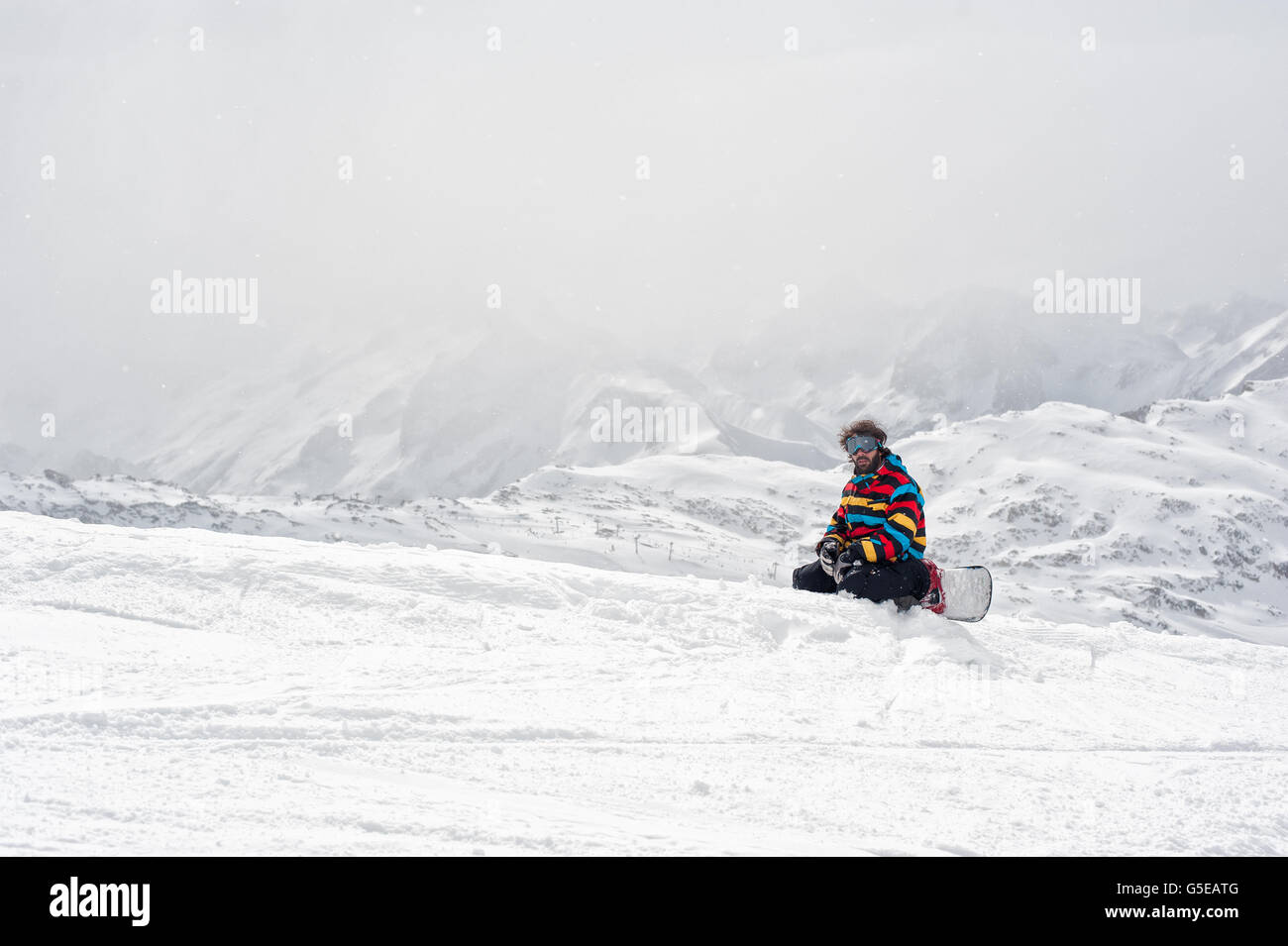 Snowboarder sit at top of mountain. Winter Scenic in the French Alps ...