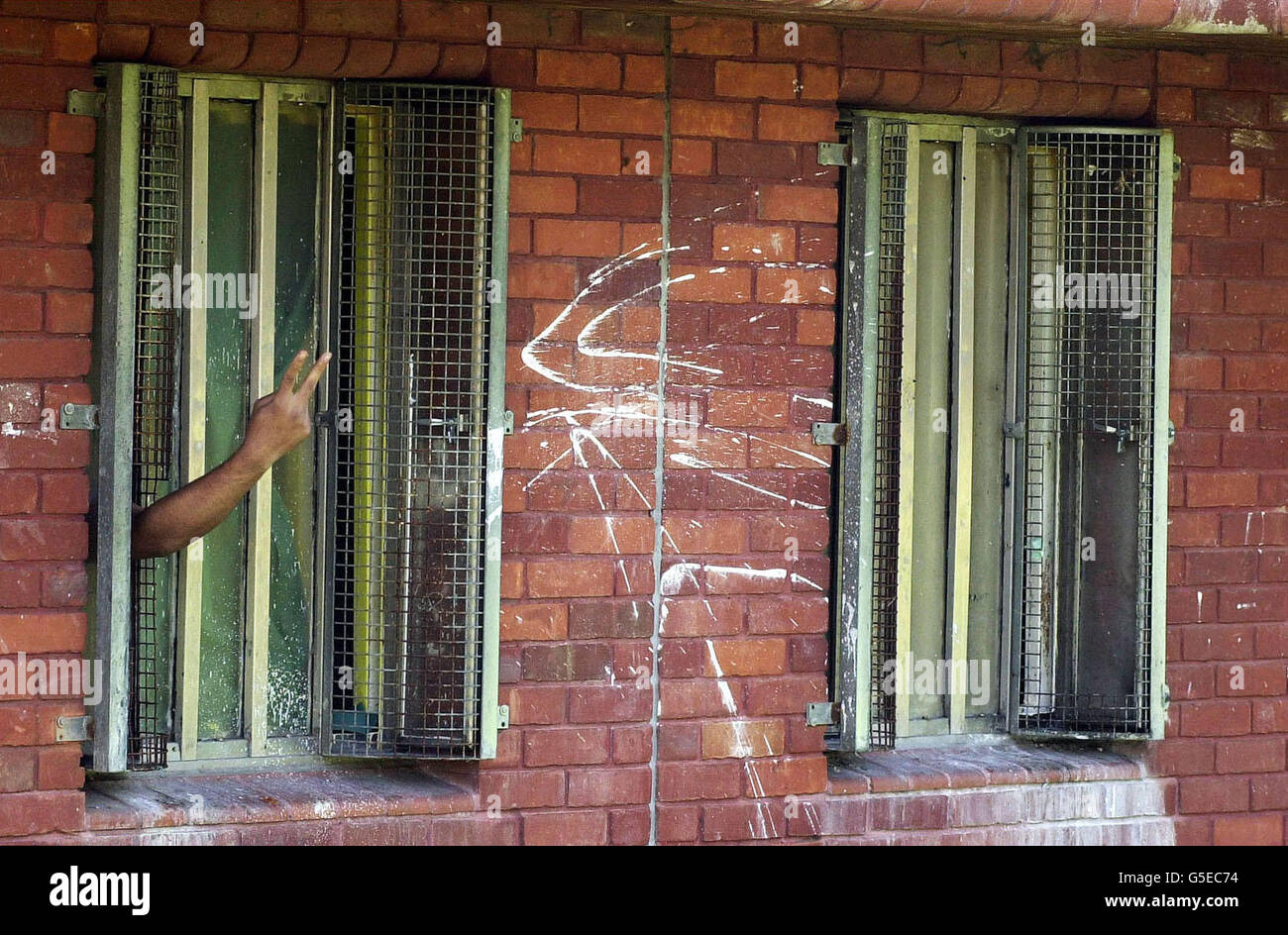 An inmate gestures through the bars of his cell window at HMP Feltham B ...