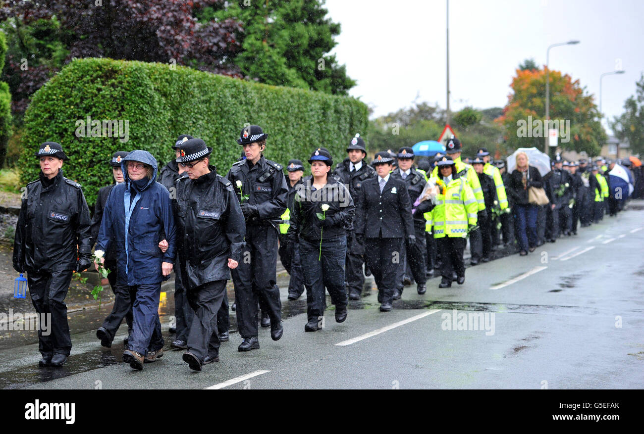 A parade of family, friends and colleagues walk through the streets of ...