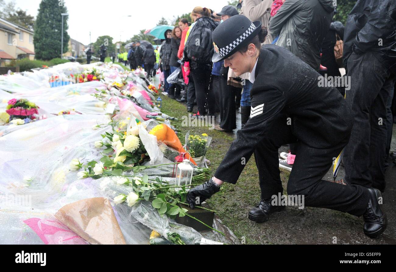 A police officer lays flowers after a vigil near Abbey Gardens ...