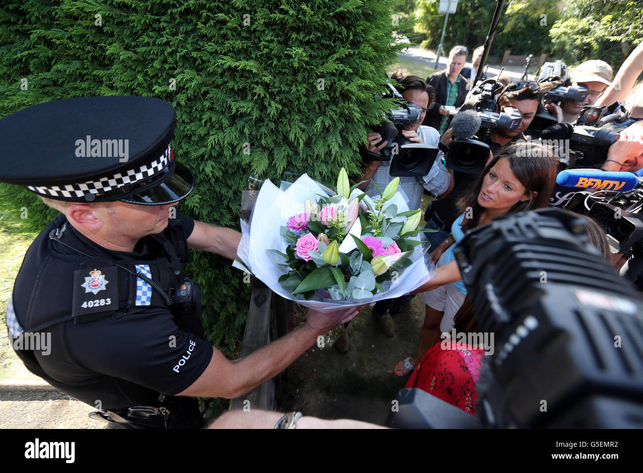 A police officer accepts flowers outside the home of French shooting ...
