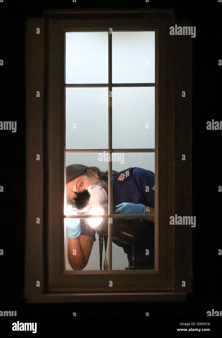 A British Scene of Crime Officer (SOCO) checks for prints as the search ...