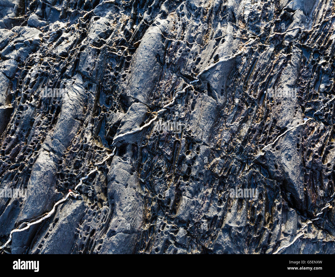 Part of rock closeup with white stripes of another geological material ...
