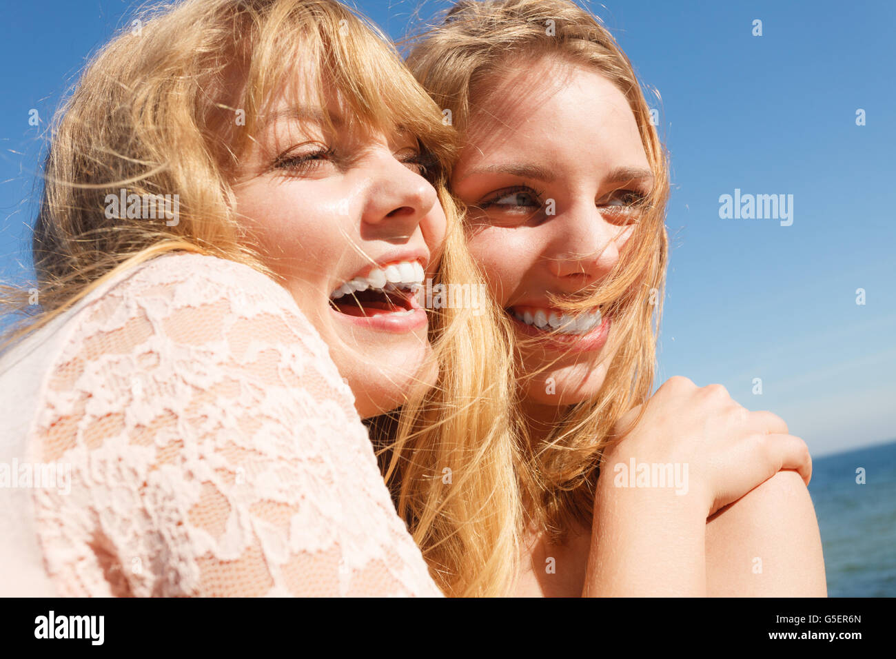 Two young women best friends blonde cheerful girls having fun outdoor ...