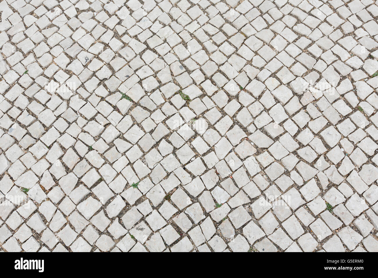 Cobbled road closeup in town as background Stock Photo - Alamy