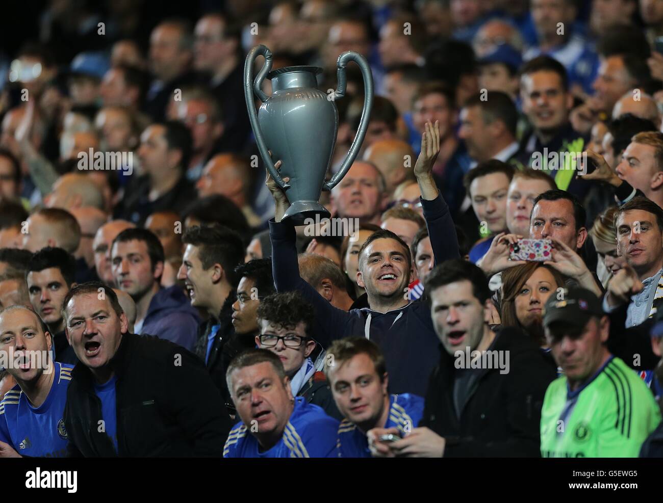 Chelsea fans hold up a trophy in the stands hi-res stock photography ...
