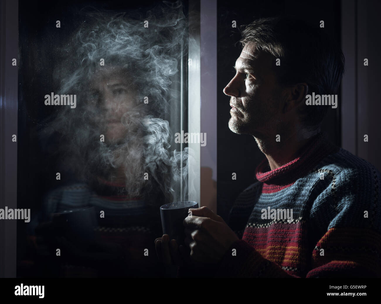 Man looking at his reflection in the window Stock Photo - Alamy