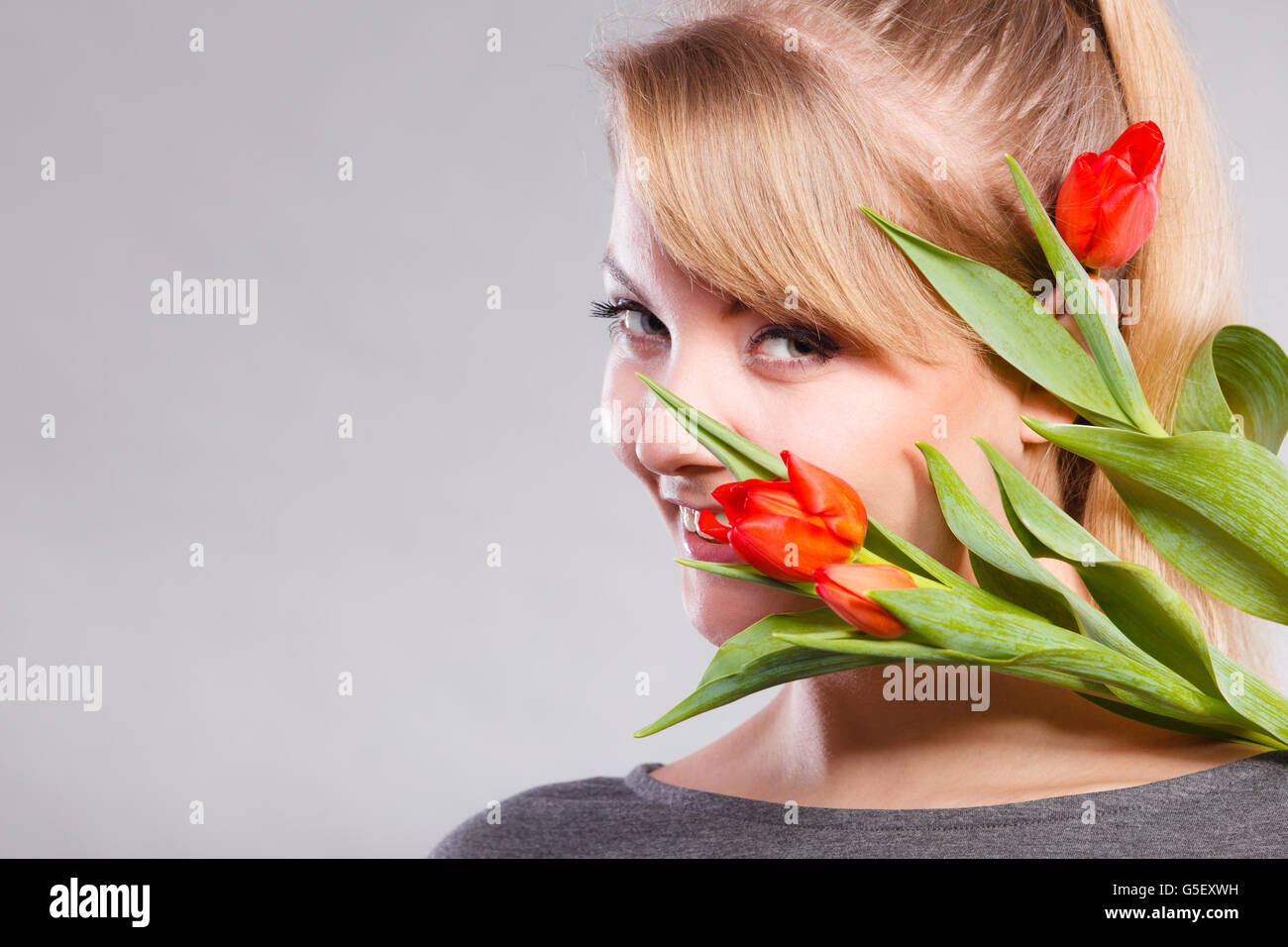 People and nature. Young woman with tulip on her face live in peace ...